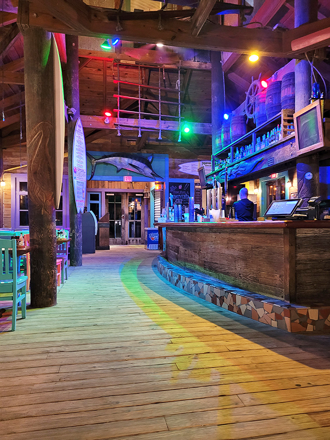 The bar area after dark transforms into a neon-lit grotto where tropical drinks flow and diet resolutions go to die.
