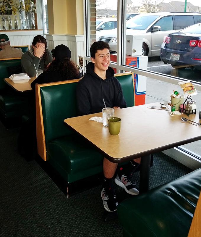 Those green booths by the window are prime real estate for people-watching while debating whether to order a second round of pancakes.