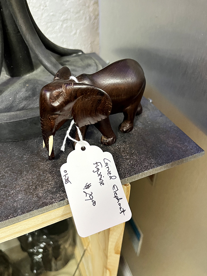 This carved wooden elephant carries both artistic craftsmanship and the weight of someone's travel memories on its tiny tusks.