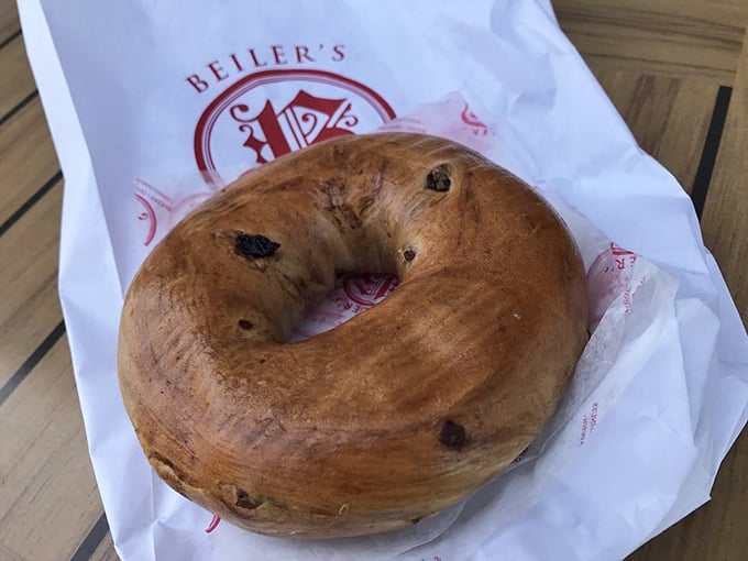 A cinnamon raisin bagel nestled in crisp white paper&mdash;proof that Beiler's excellence extends beyond the donut universe.