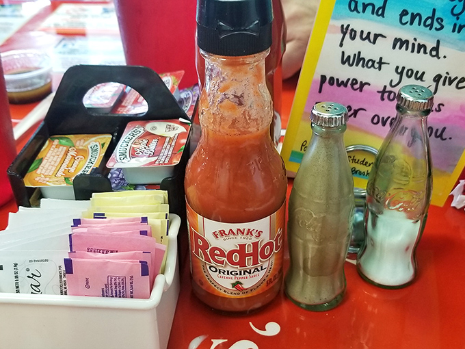 The condiment caddy&mdash;silent guardian of flavor customization, where hot sauce waits patiently for its moment to shine.