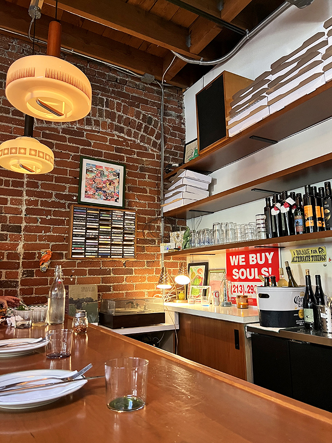 Exposed brick and vintage lighting create the perfect backdrop for wine bottles standing at attention, ready for their culinary duty.