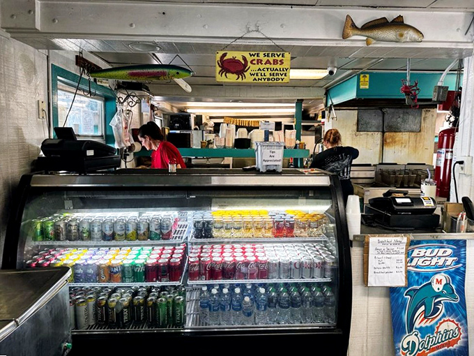 Behind this counter, seafood magic happens. The sign promising crabs is both a menu item and a philosophy: "We serve anybody."