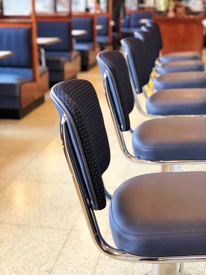 Counter seats lined up like blue vinyl soldiers, ready for solo diners seeking both breakfast and brief human connection.