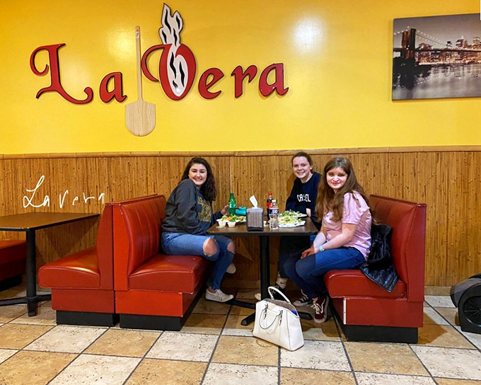 The bright yellow walls and red booths create the perfect backdrop for pizza memories. Where friends gather and calories don't count.