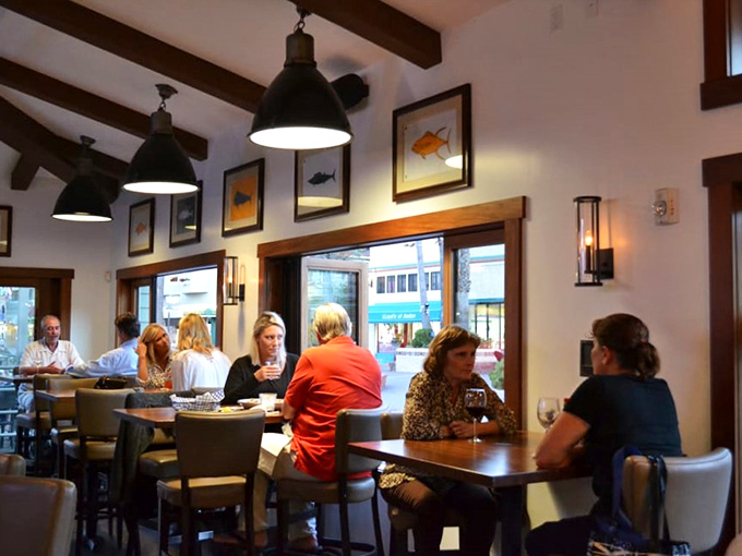 Dining at Bluewater is a social affair where conversations flow as freely as the wine, under pendant lights and framed fish art.