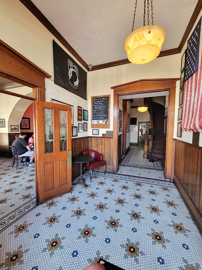 The entrance hall's vintage tile floor tells stories of a century of footsteps, while wood paneling and stained glass doors welcome you like an old friend.