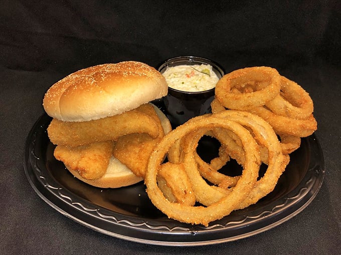 A perfectly fried fish sandwich with onion rings standing at attention. This plate doesn't need fancy garnishes—it lets the freshness do all the talking.