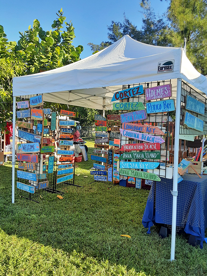 Colorful handcrafted signs capture the spirit of coastal Florida. This artisan's booth at the Cortez festival transforms weathered wood into vibrant local treasures.