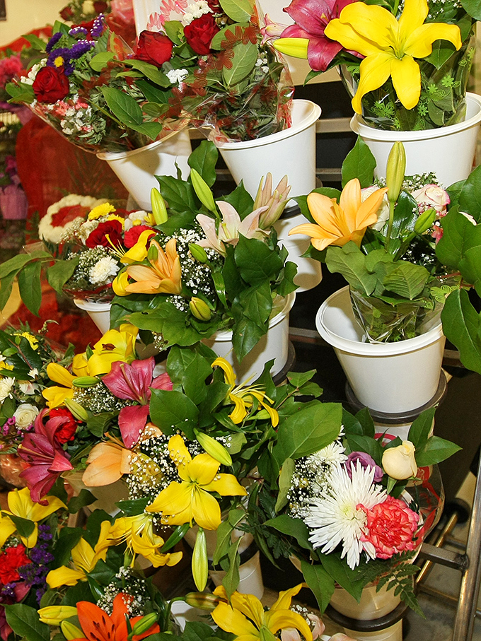 Bursts of yellow, red, and white blooms create instant joy in simple white containers. These fresh-cut bouquets transform ordinary days into celebrations.