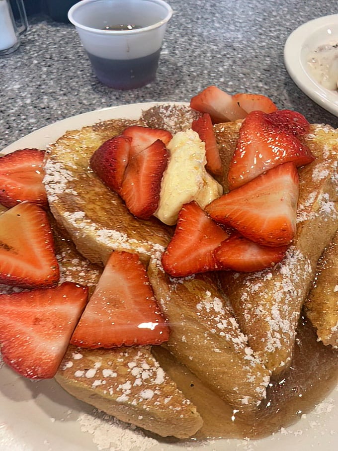 French toast elevated to art form with strawberries so vibrant they look like they're auditioning for a fruit catalog cover shoot.