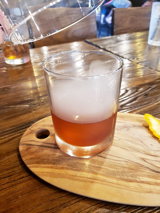 A cocktail served on a wooden board &ndash; because in 2023, regular coasters are so last decade.