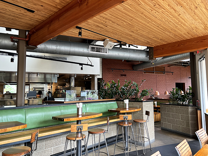 Industrial elements softened by wooden touches and plants create that rare space that feels both modern and comforting. The green banquette practically begs you to slide in with your coffee.