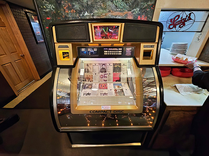 The jukebox stands as a time capsule, offering musical accompaniment to decades of pizza enjoyment and family gatherings.