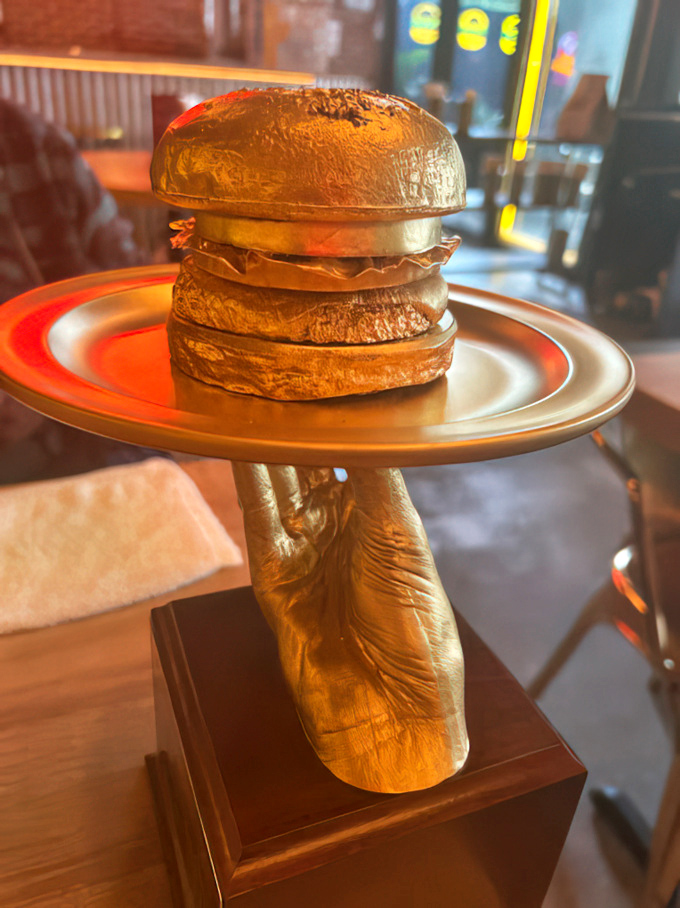 This golden burger trophy isn't just decoration&mdash;it's what your stomach would award Burgermeister after your first perfect bite.
