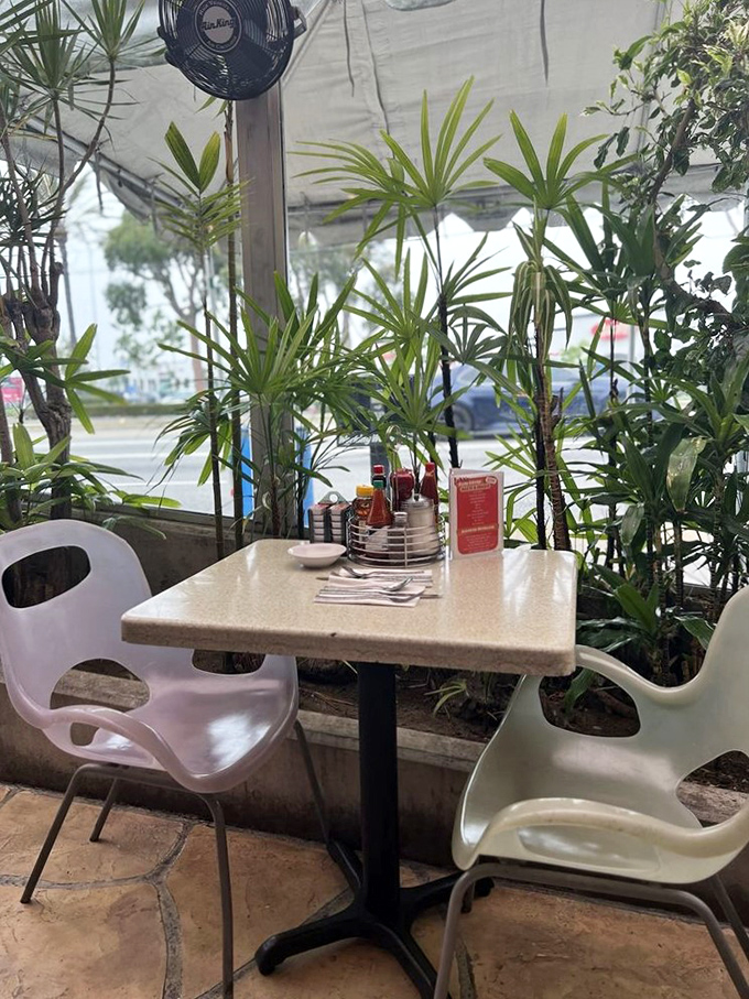 Tropical plants create a lush oasis at this outdoor table. Even the condiment caddy looks more sophisticated against this green backdrop.