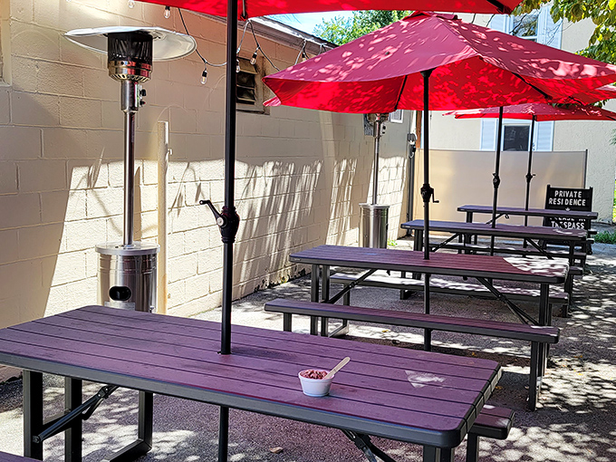 The outdoor seating area offers purple picnic tables under red umbrellas &ndash; a splash of color that matches the cafe's vibrant personality.