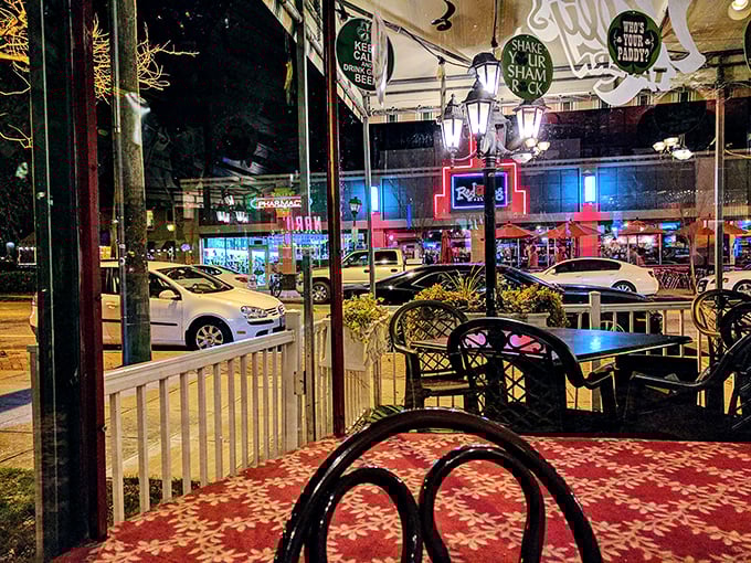 As night falls, Kelly's outdoor seating area transforms into an urban oasis. The neon glow from neighboring businesses creates the perfect backdrop for evening indulgences.