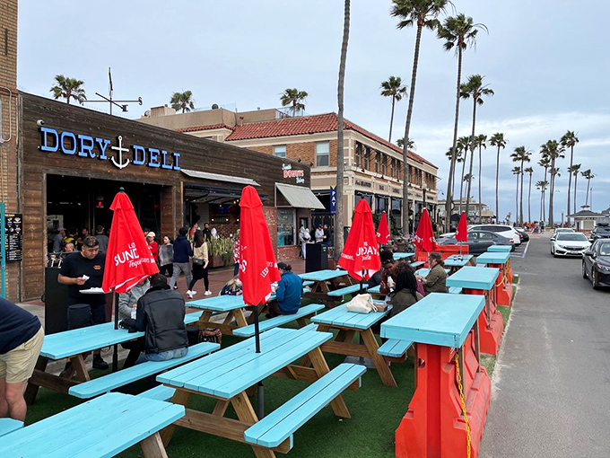 Turquoise picnic tables under California palms&mdash;because some meals deserve ocean breezes and the soundtrack of crashing waves.