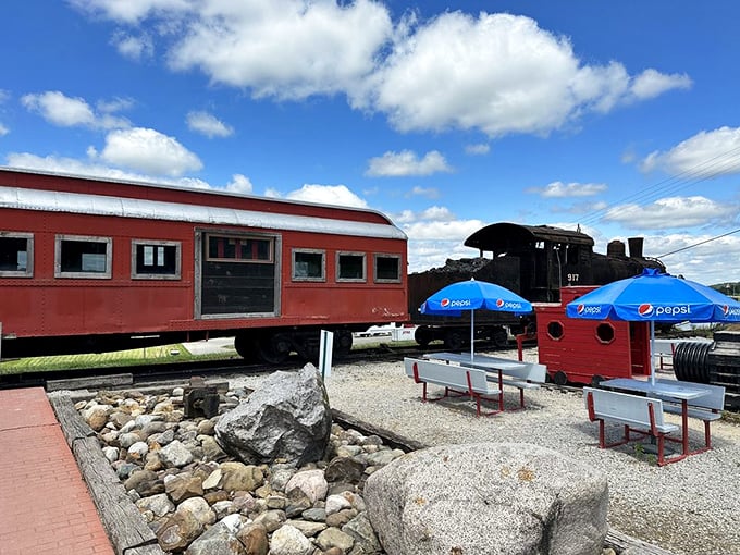 The outdoor patio offers fresh air dining with a view of the vintage locomotive, where Pepsi umbrellas provide shade for hungry rail enthusiasts.