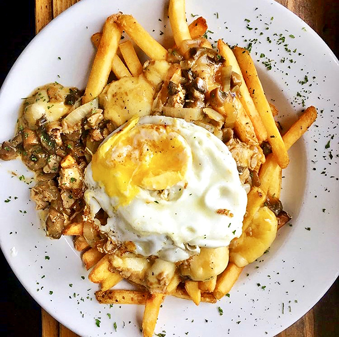 Fries topped with savory gravy, cheese curds, and a perfectly fried egg&mdash;proof that sometimes more really is more.