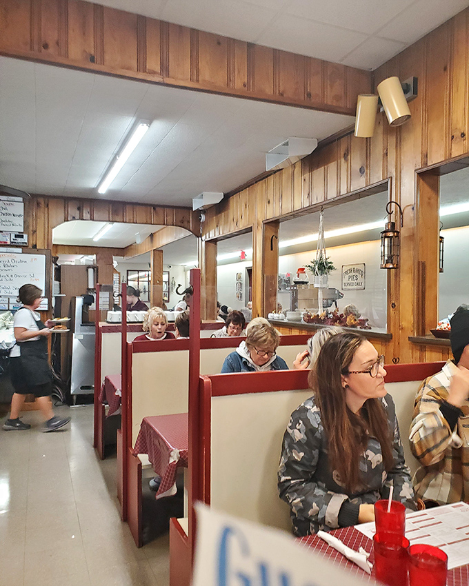Red and white booths create dining compartments of joy where strangers become neighbors over plates of home-cooked goodness.