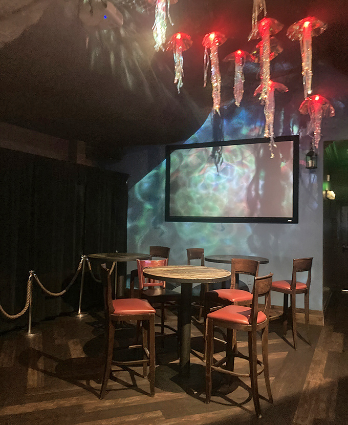 A cozy corner table awaits beneath glowing jellyfish &ndash; dinner and a show, underwater-style.