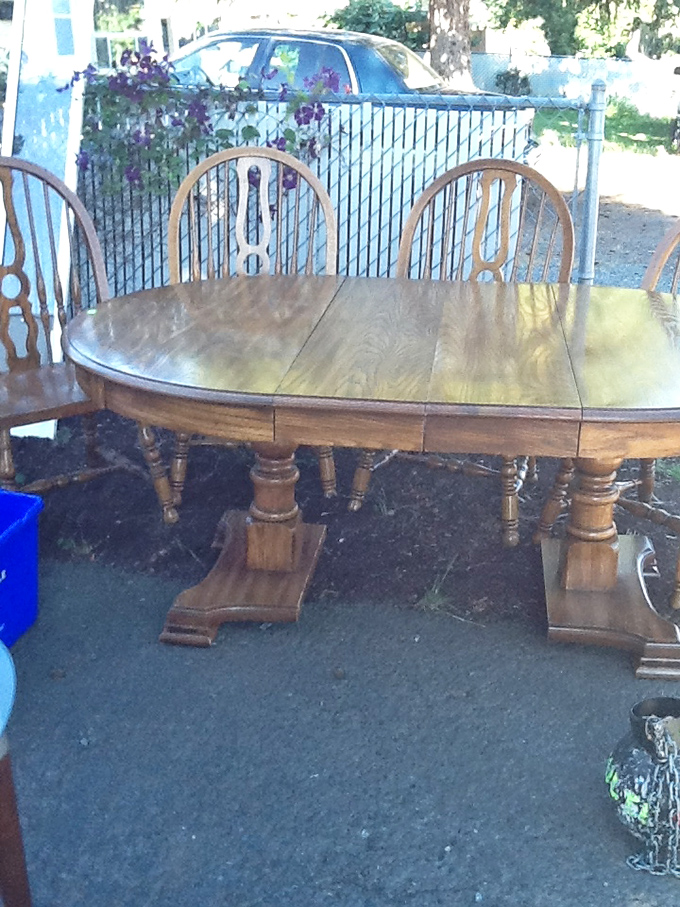 This solid oak dining table with matching chairs represents craftsmanship from an era when furniture was built to last generations.
