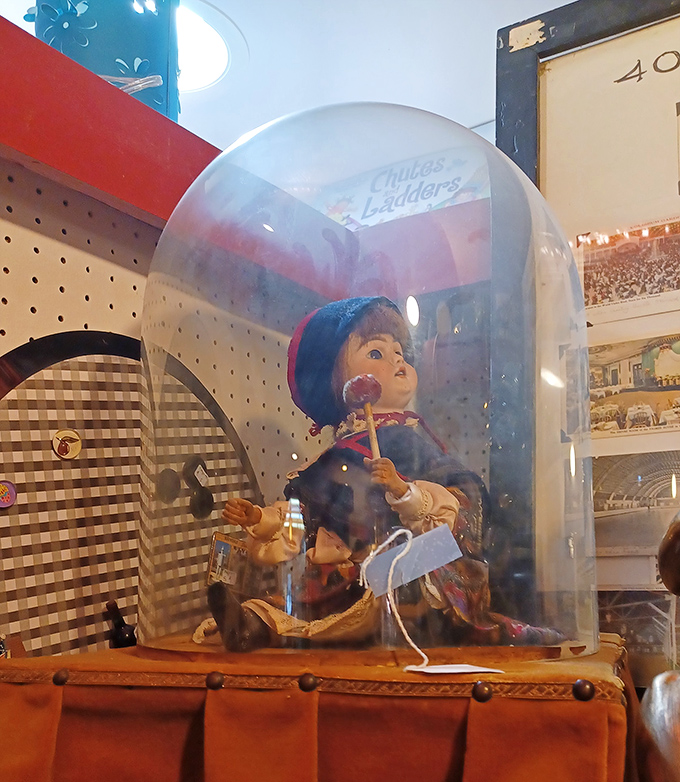This vintage doll under glass looks like she's waiting for midnight when the antique store comes alive and she can share stories with the other treasures.