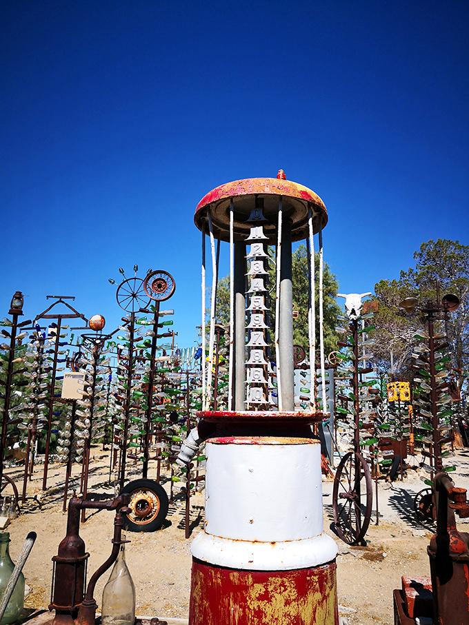 This vintage gas pump tower stands like a strange temple to American road culture, bottles hanging like offerings to the highway gods.
