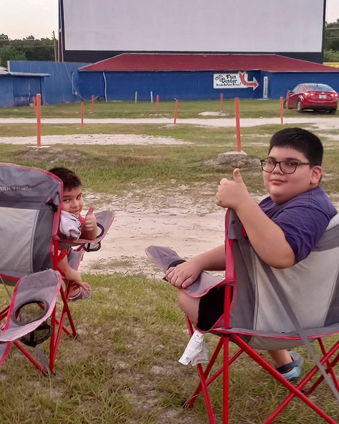 Two young moviegoers give the universal thumbs-up of approval&mdash;the drive-in's ultimate critics who know comfortable chairs and good sightlines are everything.