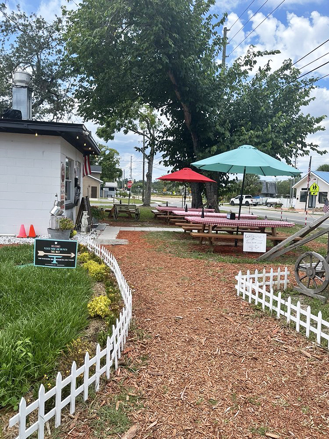 The pathway to the entrance feels like walking into a friend's backyard cookout. White picket fence, mulch, and colorful plantings set a homey tone.