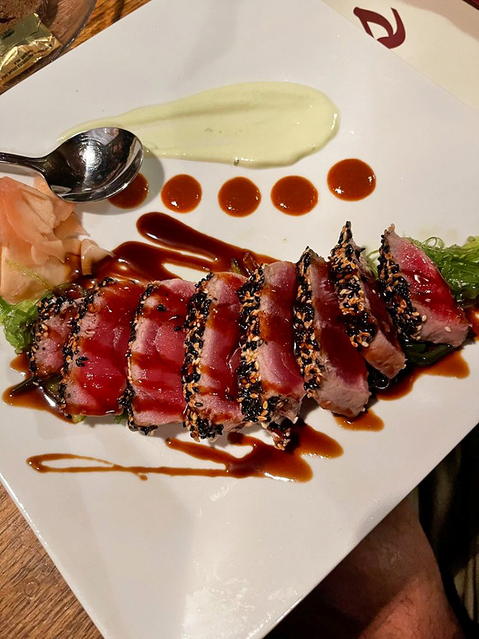 Seared ahi tuna, artfully presented with precision that would make a surgeon jealous. Each sesame-crusted slice promises a perfect bite.