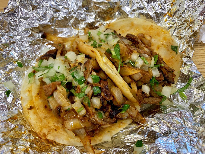 Foil-wrapped treasures revealing al pastor tacos with that perfect balance of savory meat, fresh onions, and cilantro. Taco Tuesday just got serious.