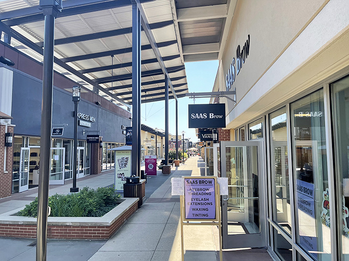 Perfectly manicured walkways guide shoppers between temptations. That SAAS Brow sign promises to fix what your eyebrows did during the pandemic.