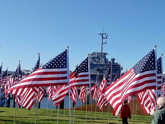A sea of American flags creates a powerful visual salute to service members, waving in Charleston's harbor breeze like a chorus of silent thank-yous