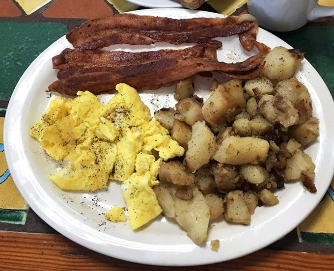 The breakfast trinity&mdash;golden eggs, crispy bacon, and home fries seasoned by angels. This plate doesn't need a fancy name to be legendary.