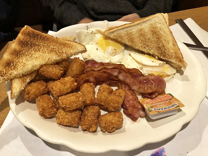 The breakfast sampler plate&mdash;where eggs, bacon, and tater tots form a golden triangle of morning perfection.