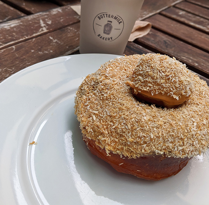 This coconut-dusted donut isn't just breakfast&mdash;it's a tropical vacation for your mouth. The coffee cup stands by, ready to wash the paradise down.