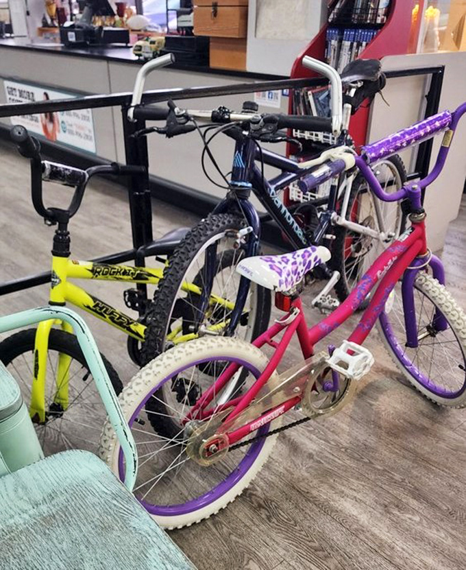 Bicycles in technicolor glory await new adventures. That purple leopard-print saddle has stories to tell about its previous rider's neighborhood journeys.