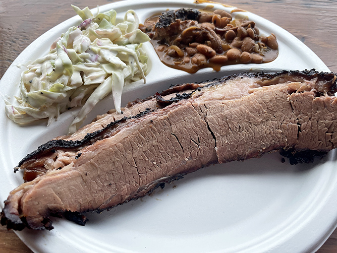 Brisket with a smoke ring so perfect it could be framed, sliced to showcase the juicy interior that's been coaxed to tenderness over hours of patient smoking.