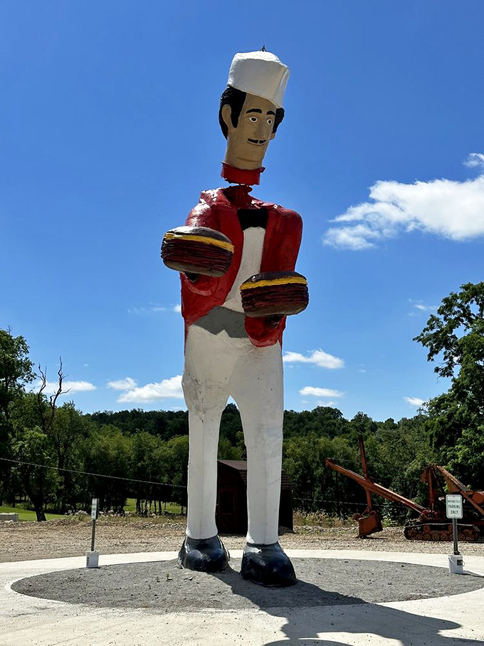 The giant chef statue stands as Ohio's quirky roadside guardian, his perpetually served burgers a promise of delights within the train cars below.