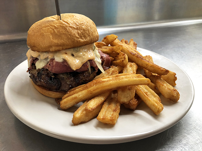 A burger that requires both hands and several napkins, paired with fries that achieve the perfect balance between crispy exterior and fluffy interior.