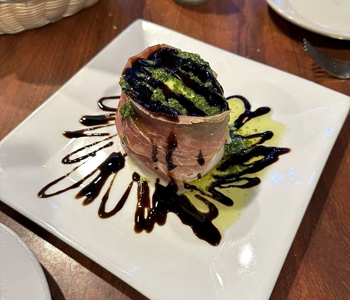 Prosciutto wrapped around fresh ingredients with artful drizzles &ndash; proof that sometimes the simplest combinations create the most memorable flavors.