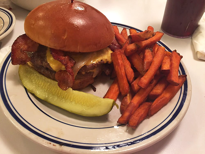 A burger that makes your cardiologist nervously check their retirement account, escorted by sweet potato fries that refuse to be upstaged.