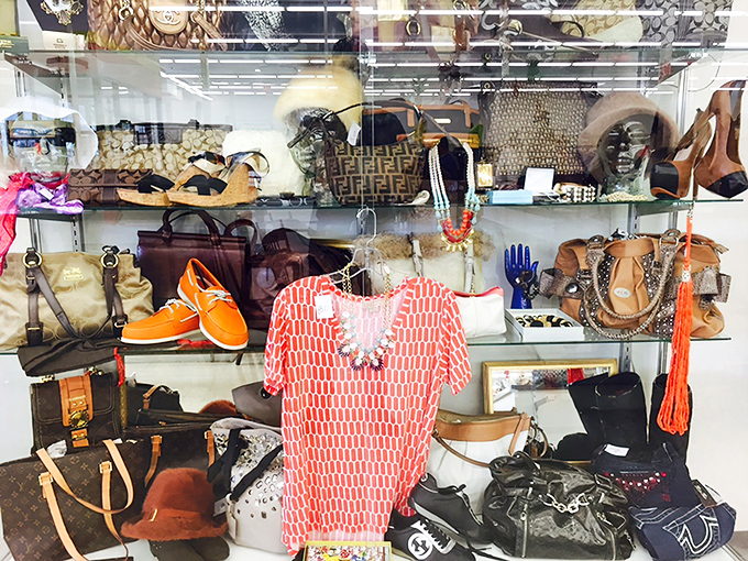 Designer bags and bright accessories behind glass&mdash;the thrift store's version of a museum display, but you can actually take these home.
