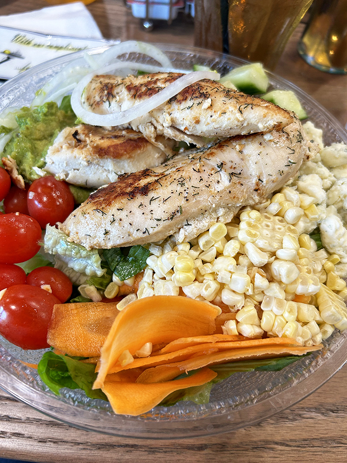 A chicken salad that somehow makes vegetables exciting—grilled perfection atop a garden of textures that's technically healthy but suspiciously delicious.