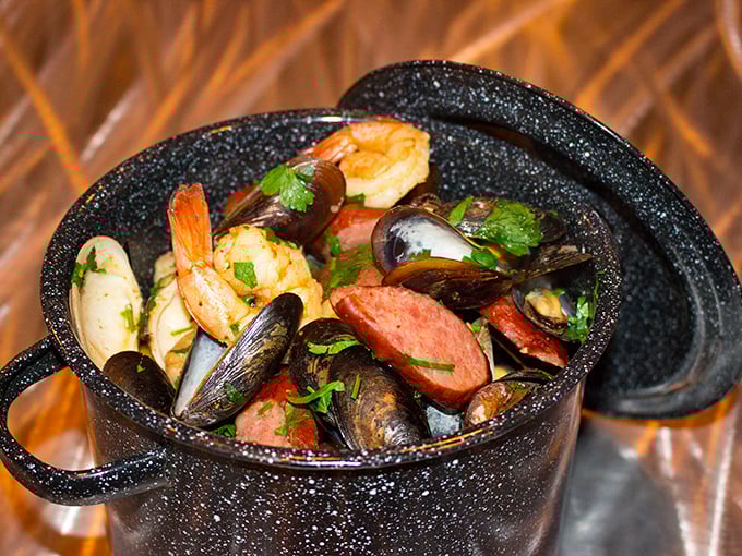 A black pot brimming with seafood treasures&mdash;mussels, shrimp, and sausage swimming in a broth worth sopping up with every available bread morsel.