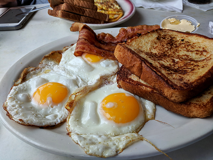 The breakfast trinity &ndash; perfectly fried eggs with golden centers, crispy bacon with just the right bend, and toast standing by for yolk duty.