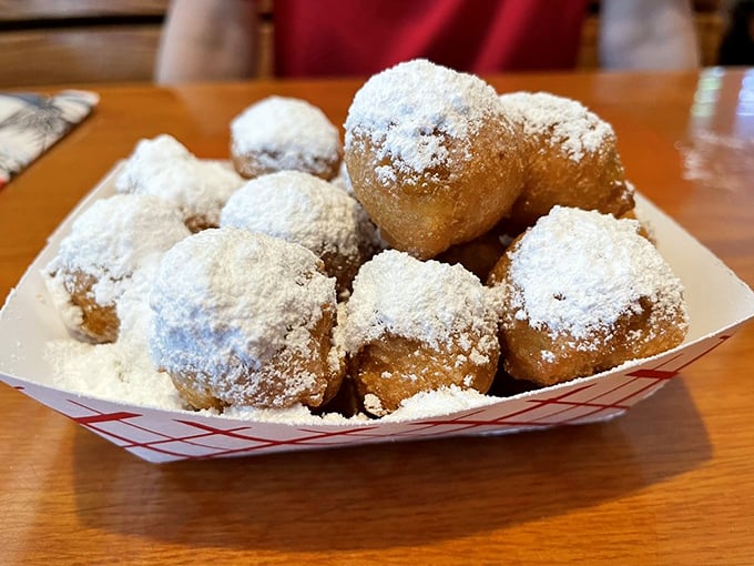 The famous corn fritters arrive like powdered sugar snowballs, creating a sweet-savory prelude that's become as legendary as the seafood that follows.